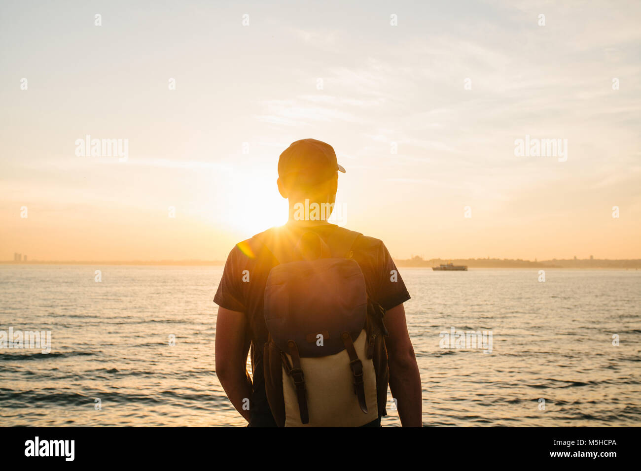 A tourist with a backpack on the coast. Travel, tourism. On the Sunset ...