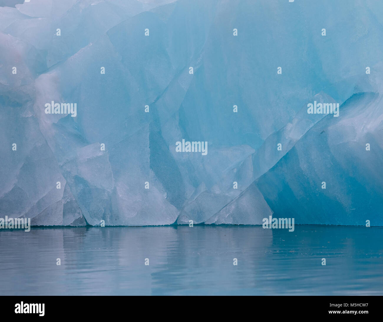 Blue ice and water. Detail of an iceberg in the Arctic Ocean at ...