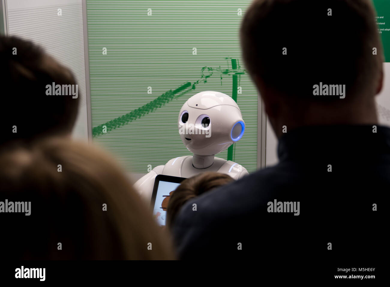 People looking at a robot looking at people Stock Photo - Alamy