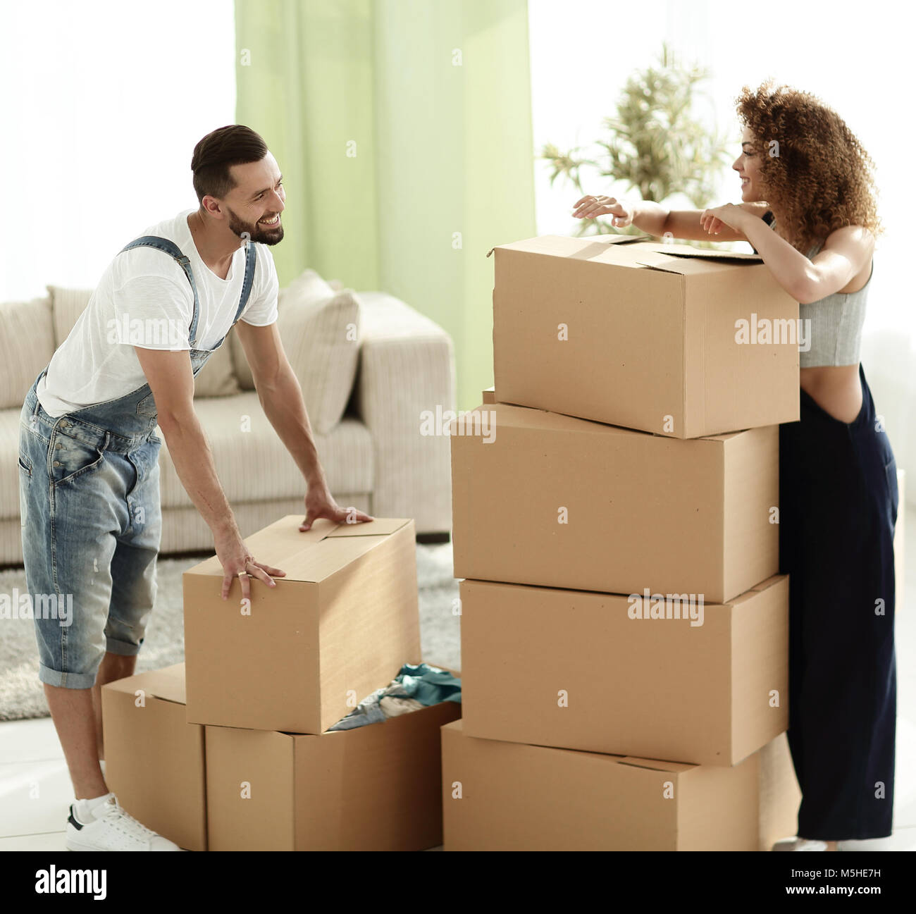 Happy and young couple looking at boxes Stock Photo - Alamy