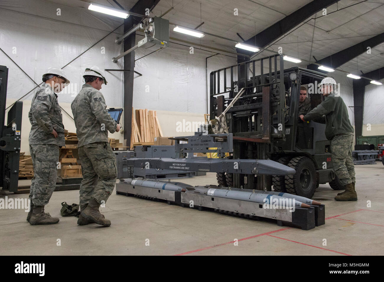 Airmen with the 3rd Munitions Squadron assemble a rack of inert small ...