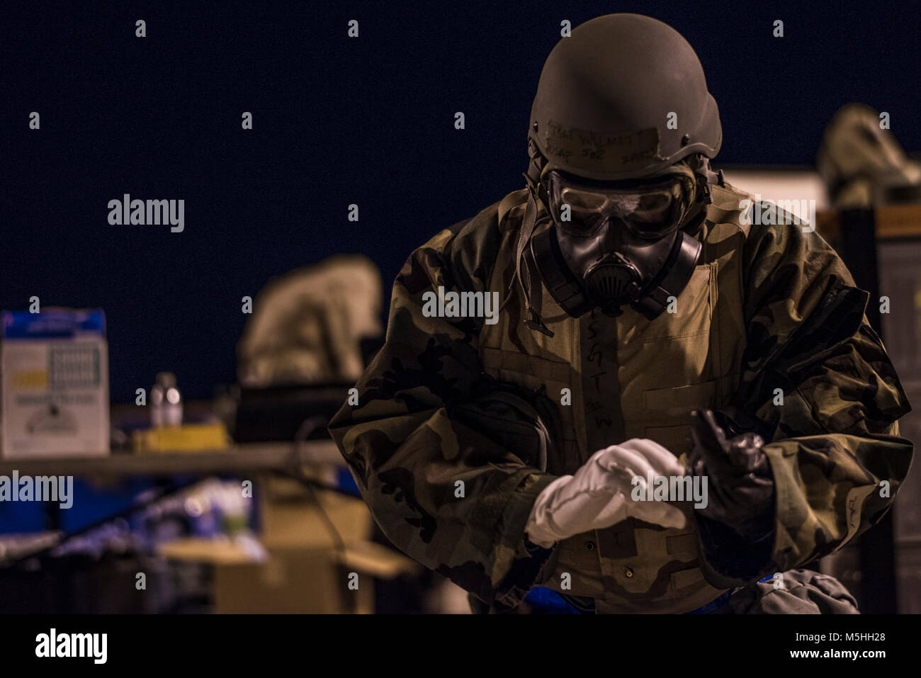 A U.S. Airman suits up in mission-oriented protective posture gear ...