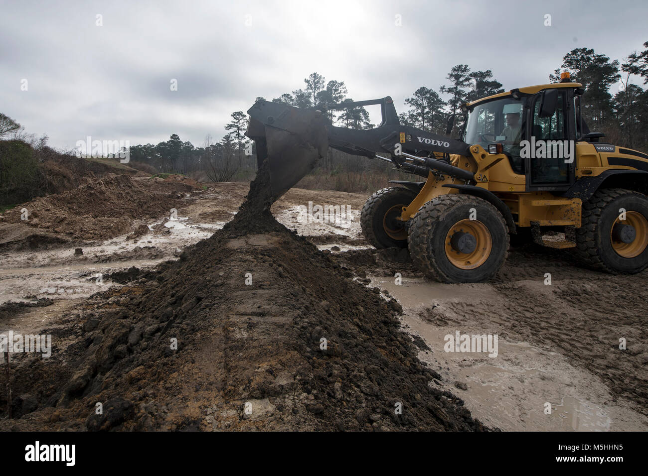 A loader drops dirt on a bern, Feb. 15, 2018, at Moody Air Force Base ...
