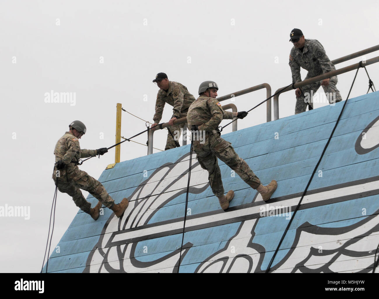 Air Assault students rapel down a slanted wall under the guidance of ...