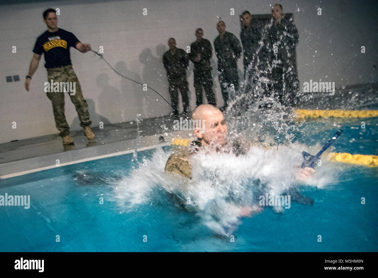 An Airman jumps into a pool during a water survival assessment, Feb. 9 ...