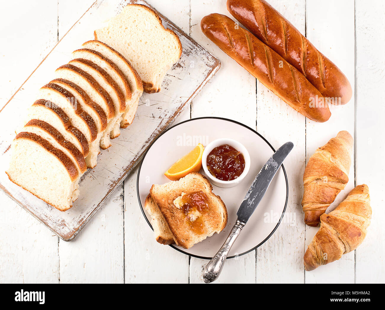 Cutting board with toast bread, jam and butter on table. Top view Stock ...