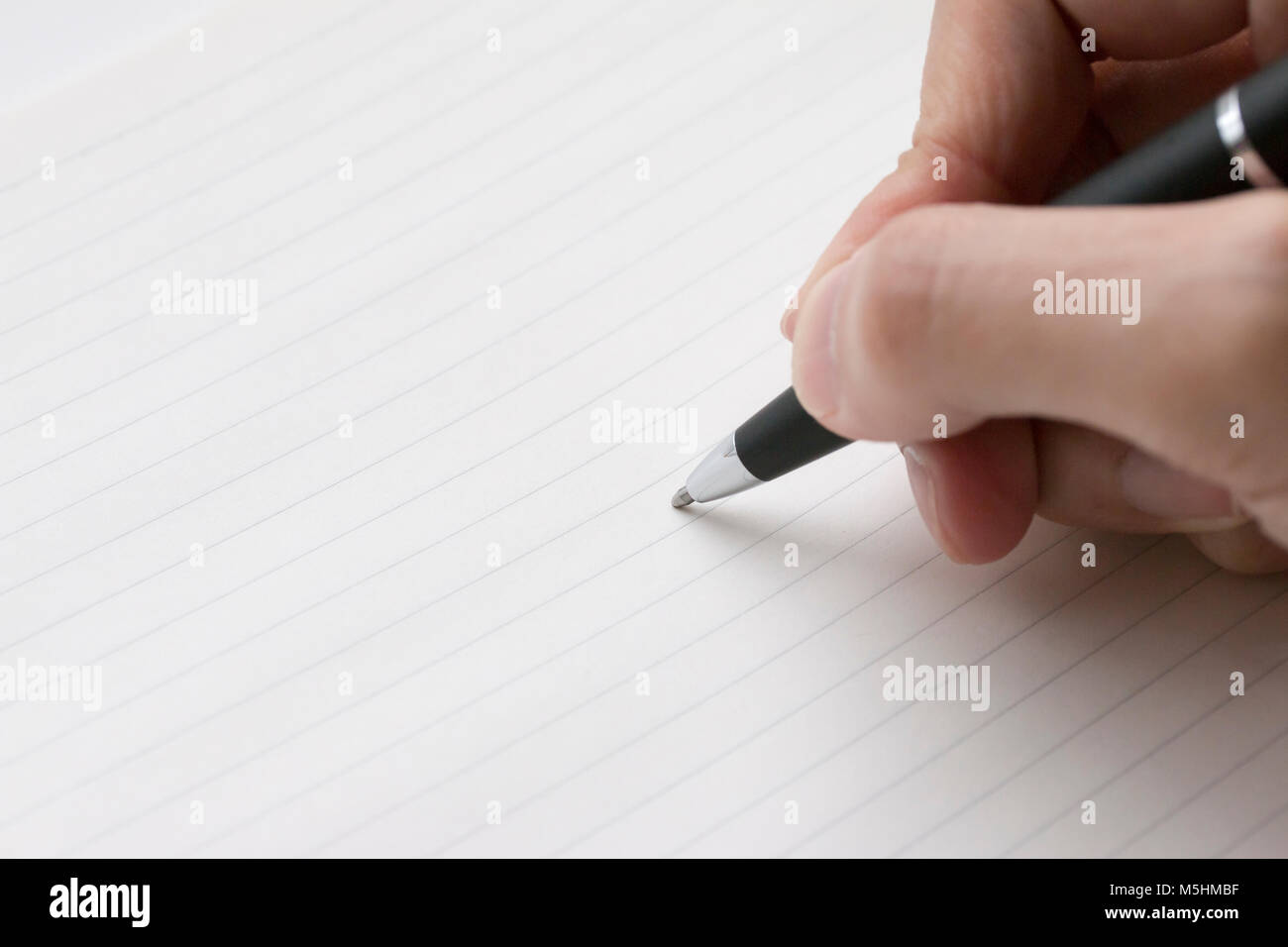 a ballpoint pen was holding in hand ready to writing in note book Stock ...