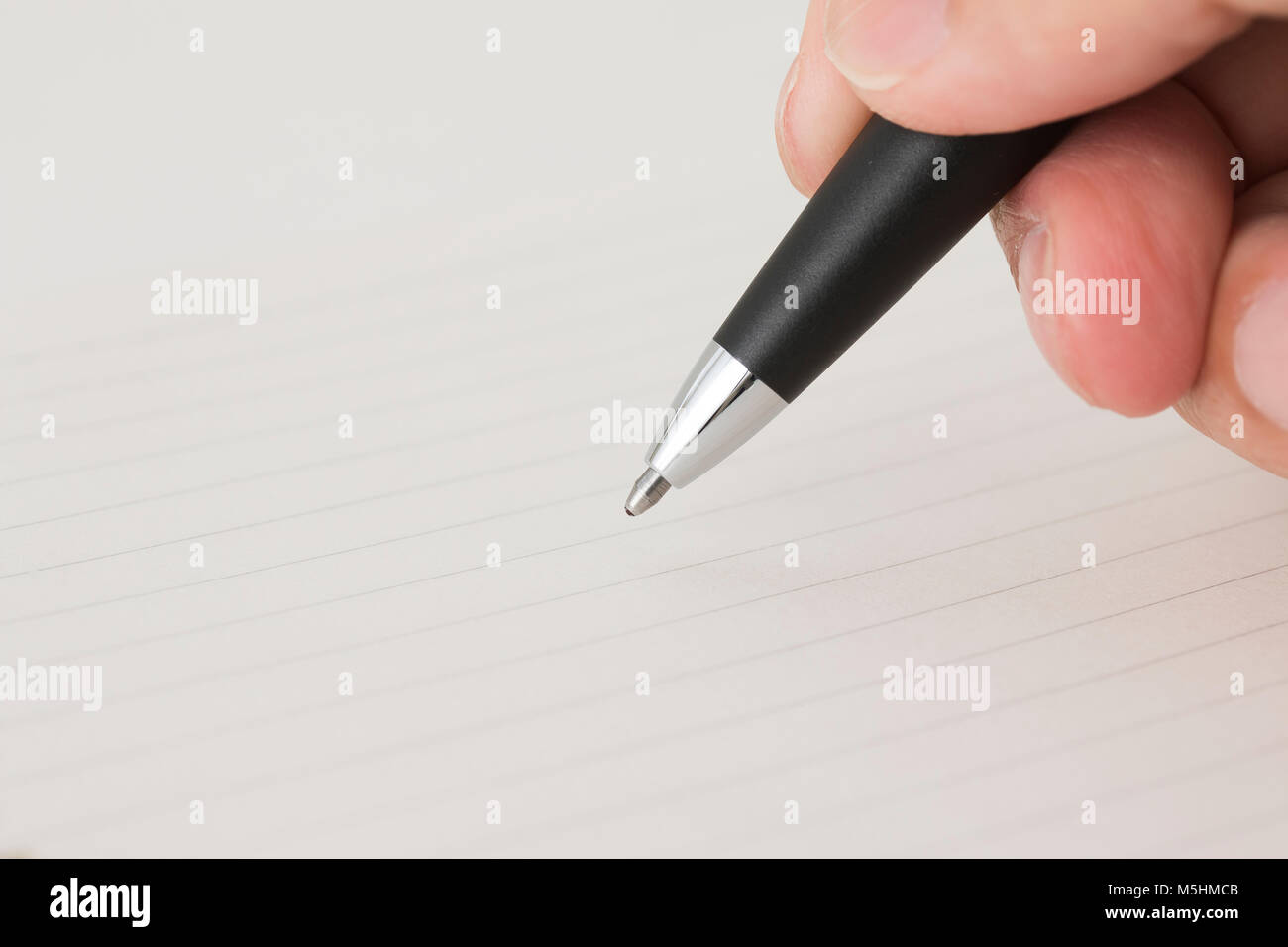 a ballpoint pen was holding in hand ready to writing in note book Stock ...