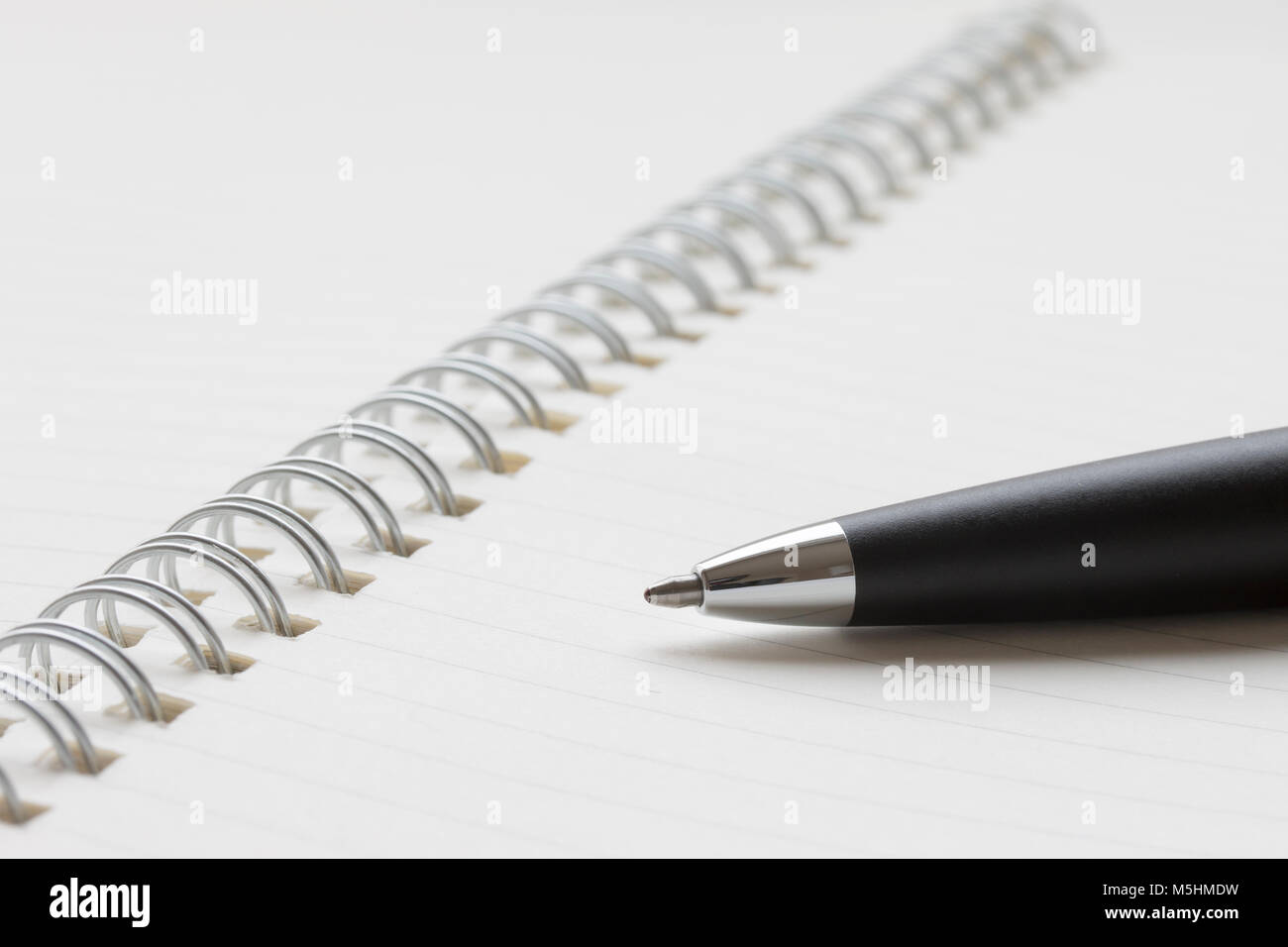 black ballpoint pen nib,on a white notebook background Stock Photo - Alamy