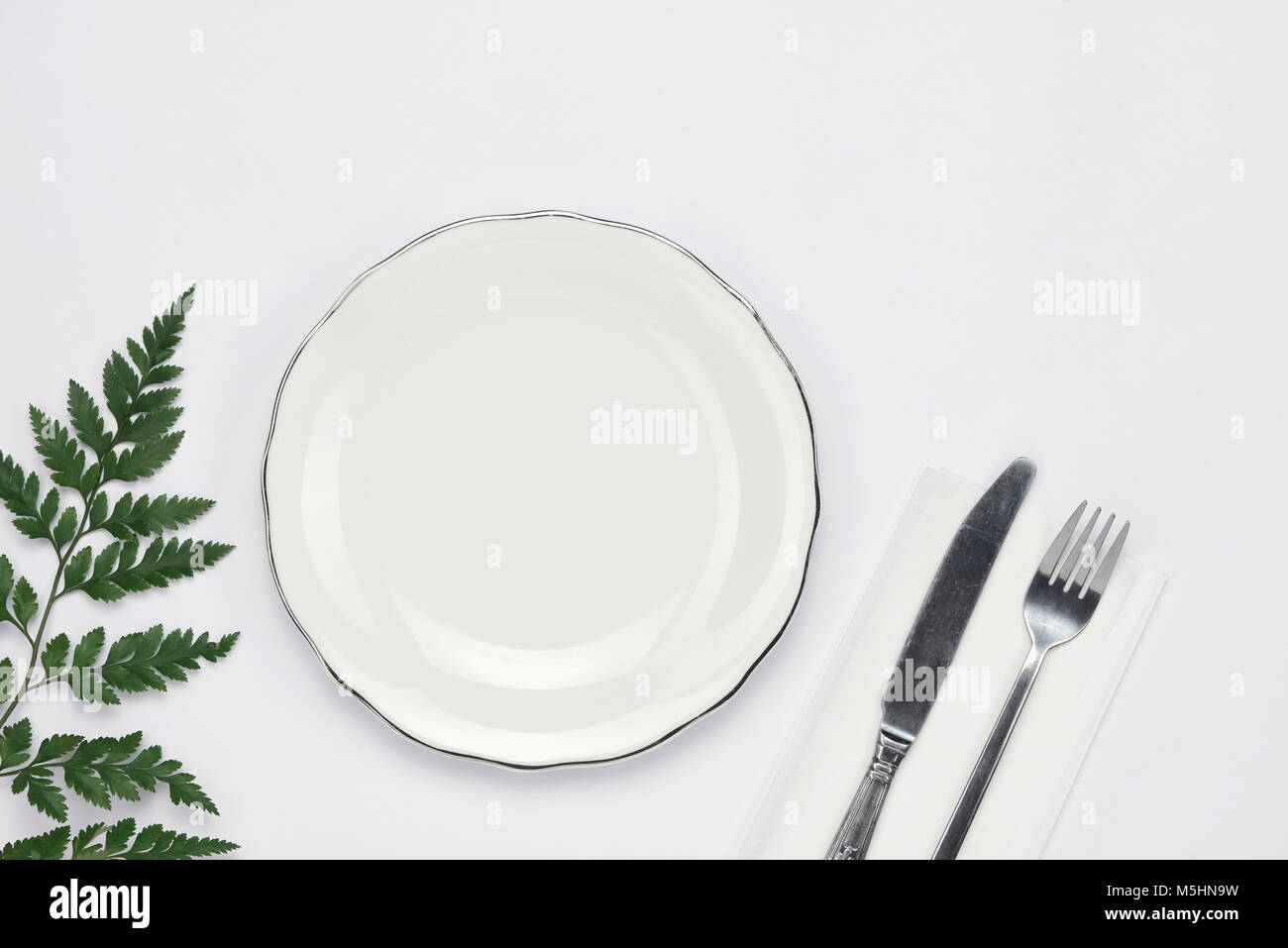 Dinner plate setting top view. Empty plate and silverware set on wooden ...