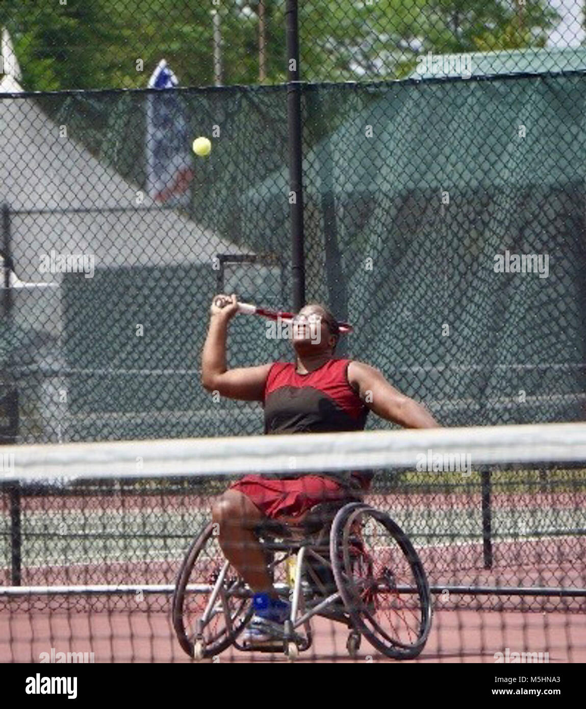 Dr. Lisa Maddox sets up for a serve while playing wheelchair tennis ...