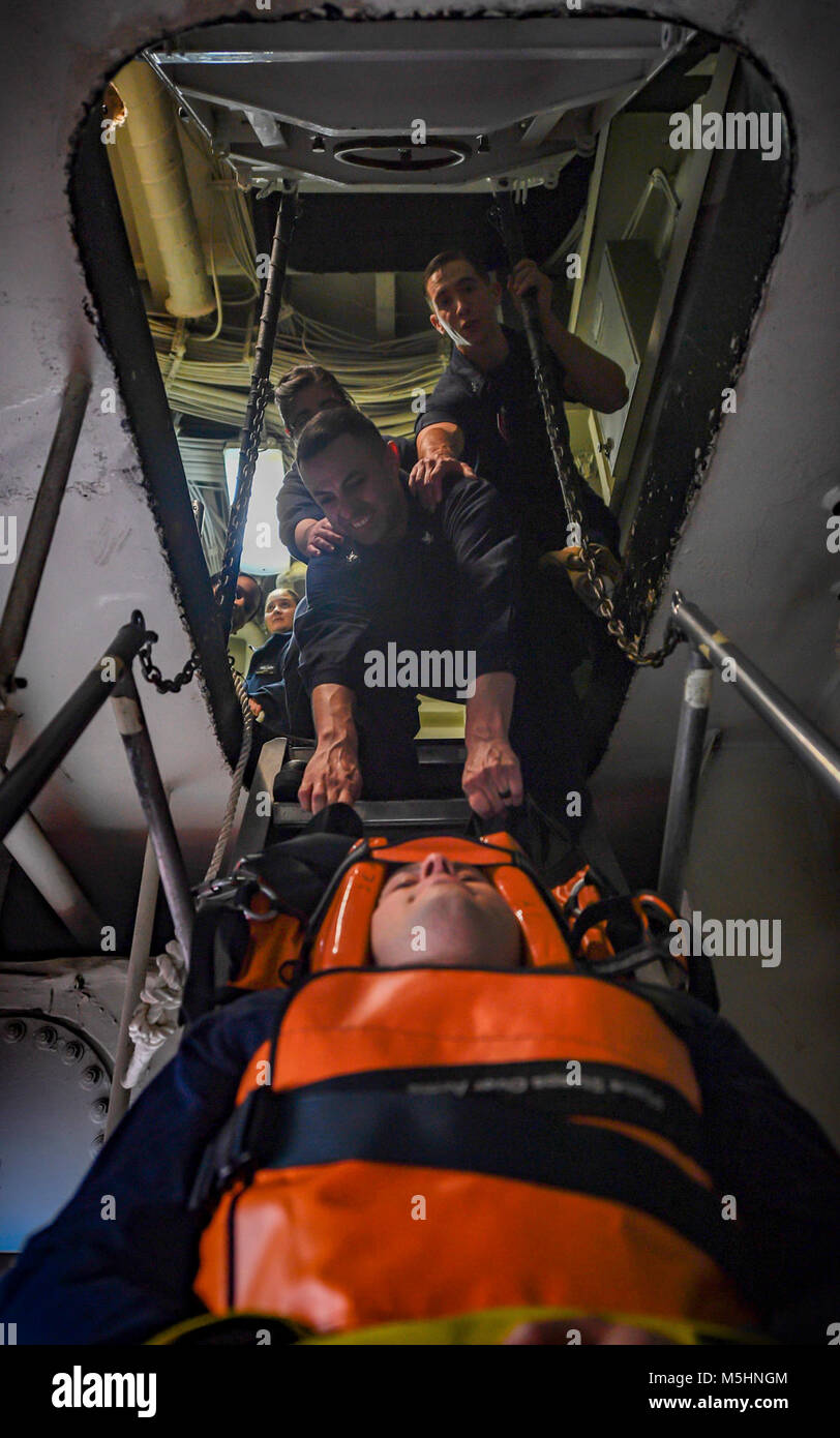 ARABIAN GULF (Feb. 13, 2018) Sailors lower a patient down a ladder well ...