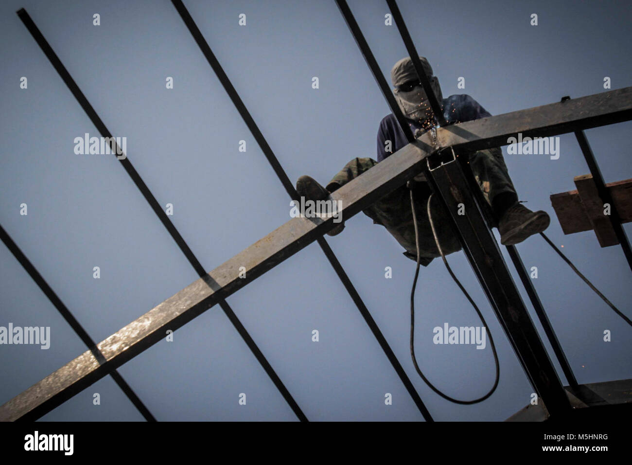 A Royal Thai Navy sailor welds rafter beams together for a construction ...