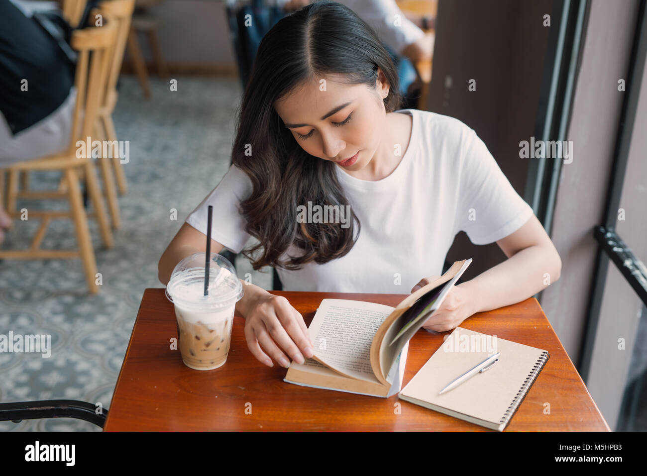 Portrait of Asian woman reading book in coffee shop cafe vintage color ...