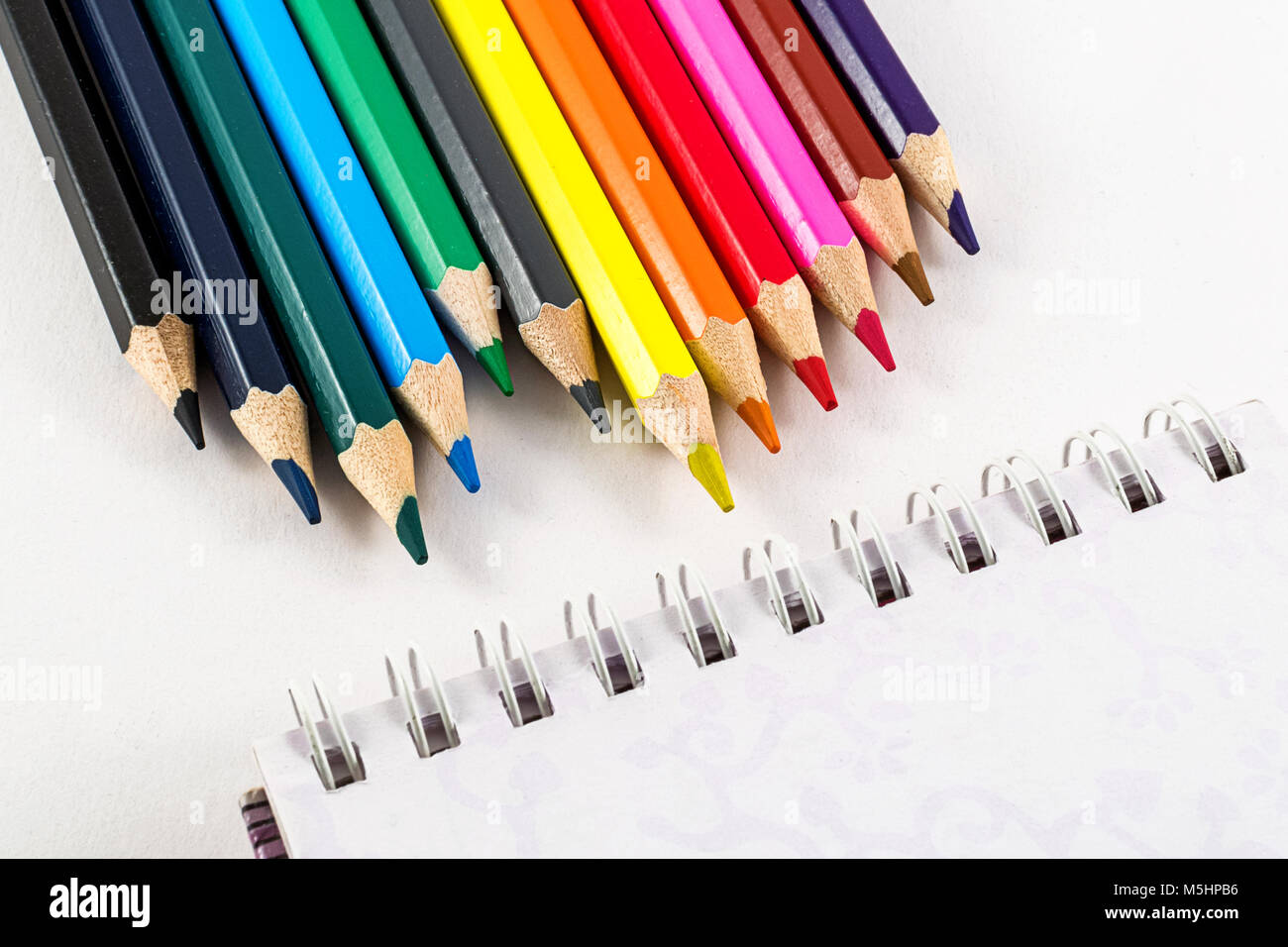 Color pencils and empty note on white background Stock Photo - Alamy