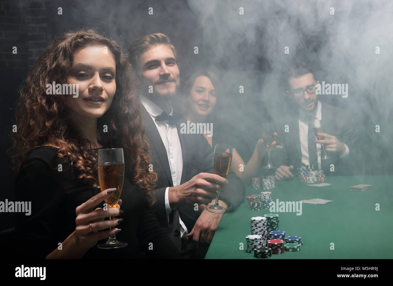 group of friends sitting at game table in casino Stock Photo - Alamy