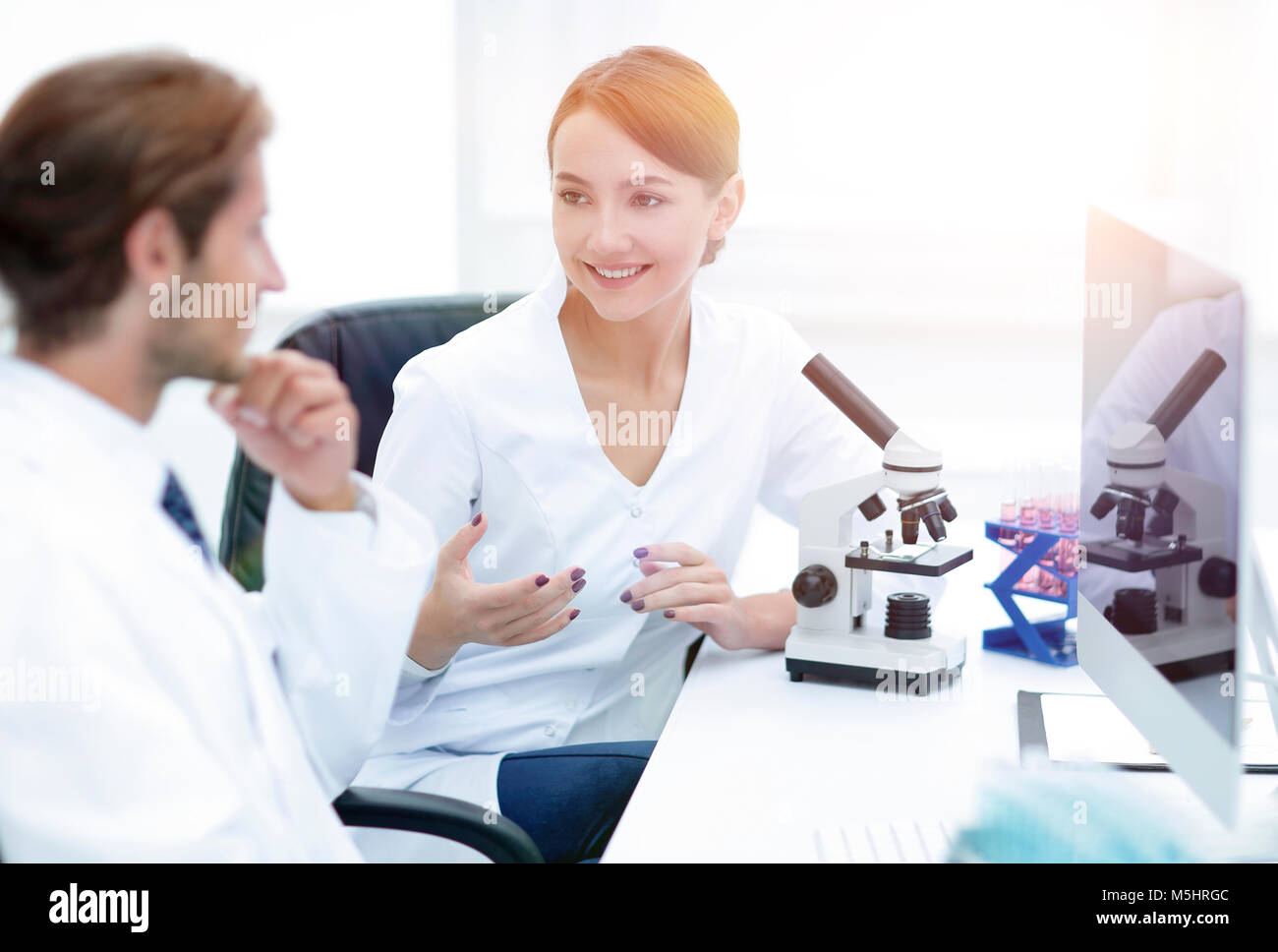 Side view of two scientists conducting a chemical experiment Stock ...