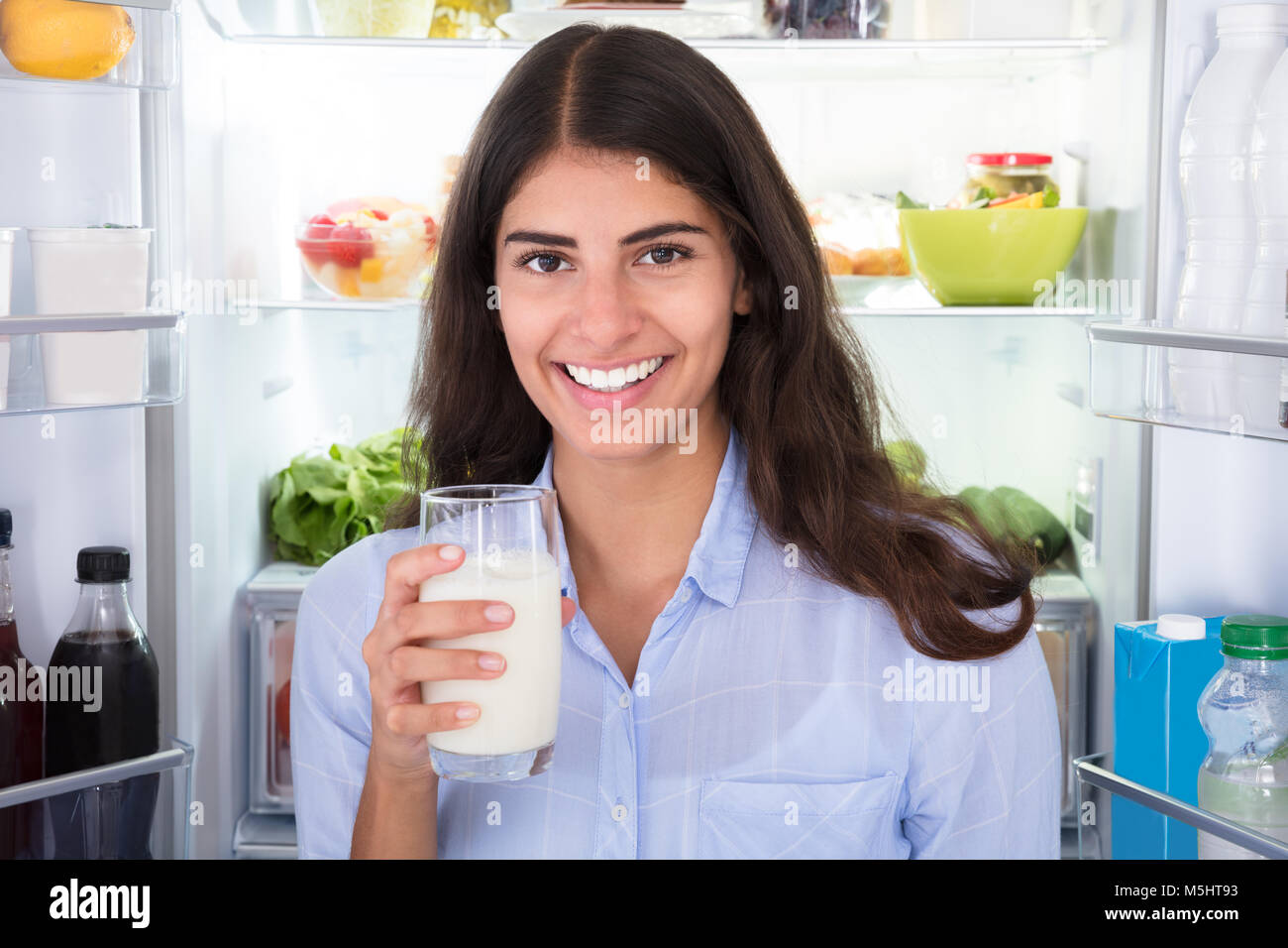 Portrait Of A Smiling Young Woman Holding Glass Of Milk Stock Photo - Alamy