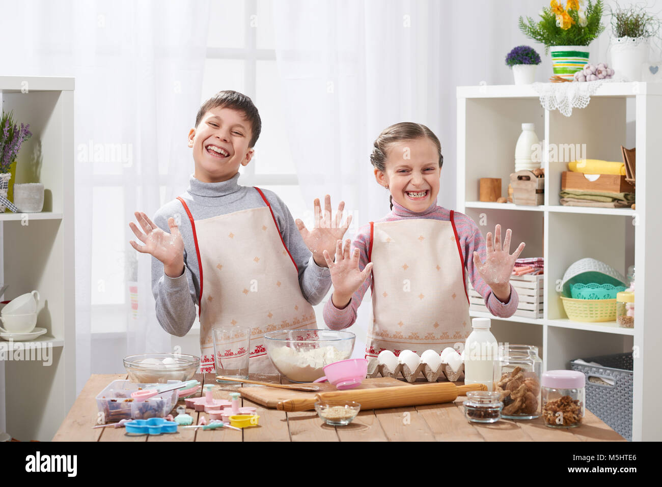 Child girl and boy cooking in home kitchen, showing hands with flour ...