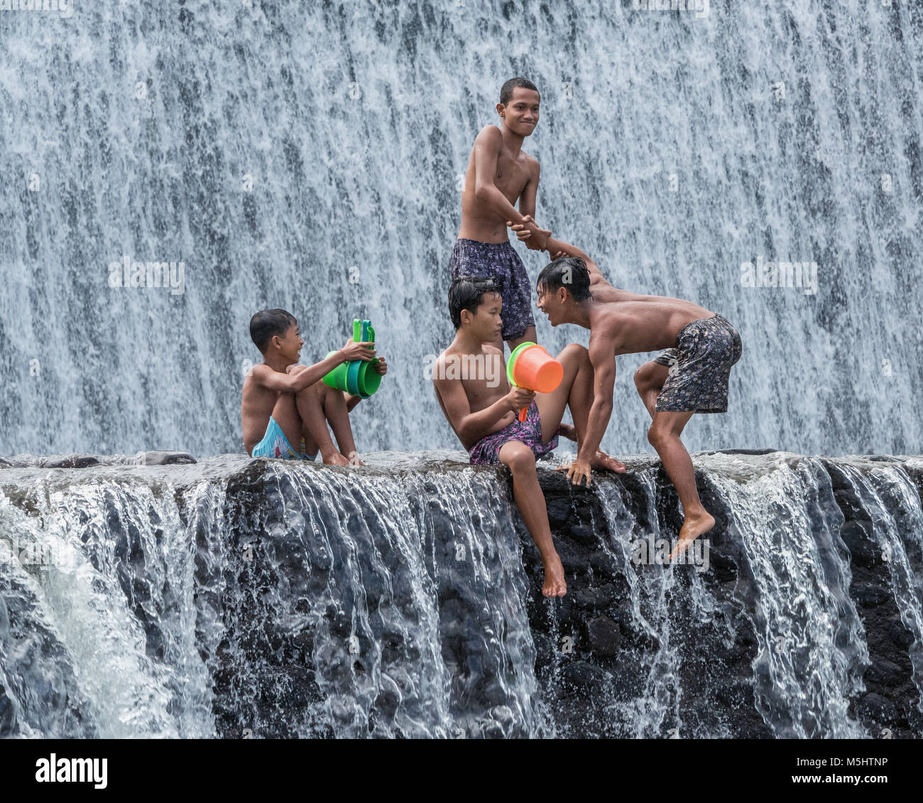 Boys playing in the Tukad Unda Dam waterfall, Klongklong, Bali Stock ...