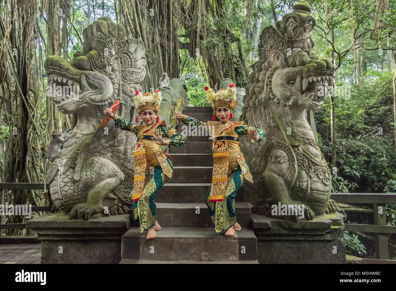 Two traditional Balinese dancers and two macaques at the Dragon Bridge ...
