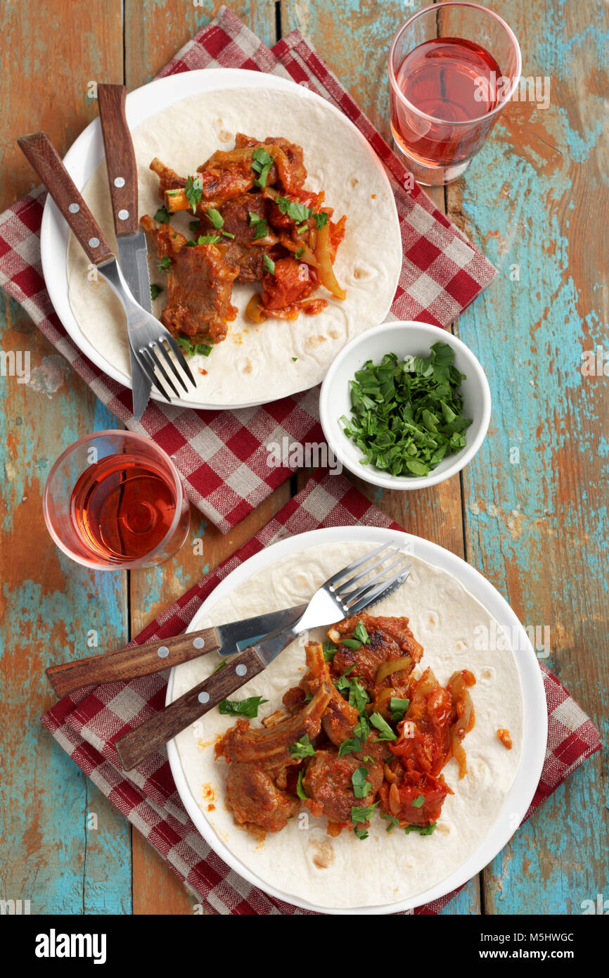 Roasted lamb chops with tomato and pepper on a rustic table Stock Photo ...