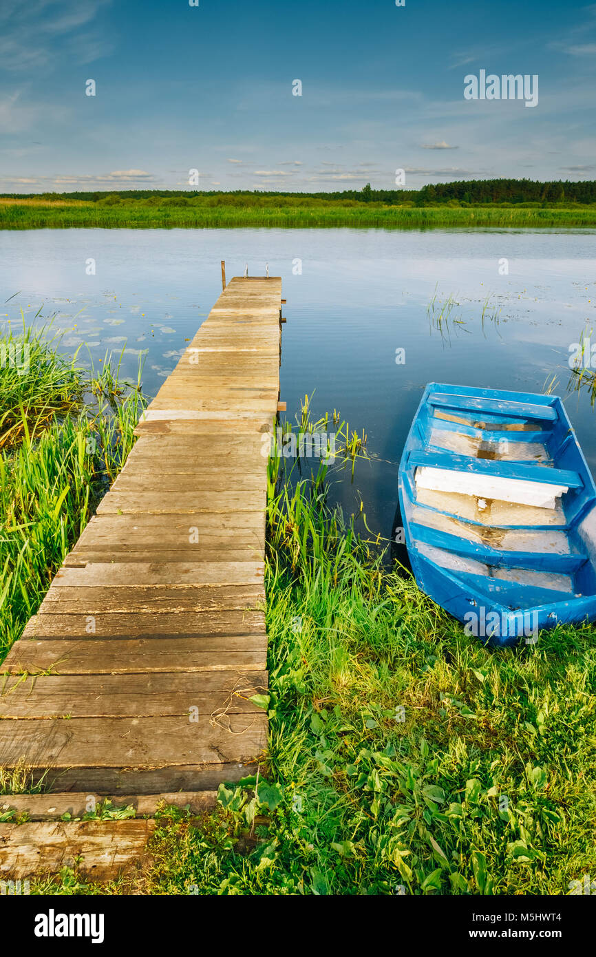 Summer landscape with a wooden small pier on the river and a fishing ...