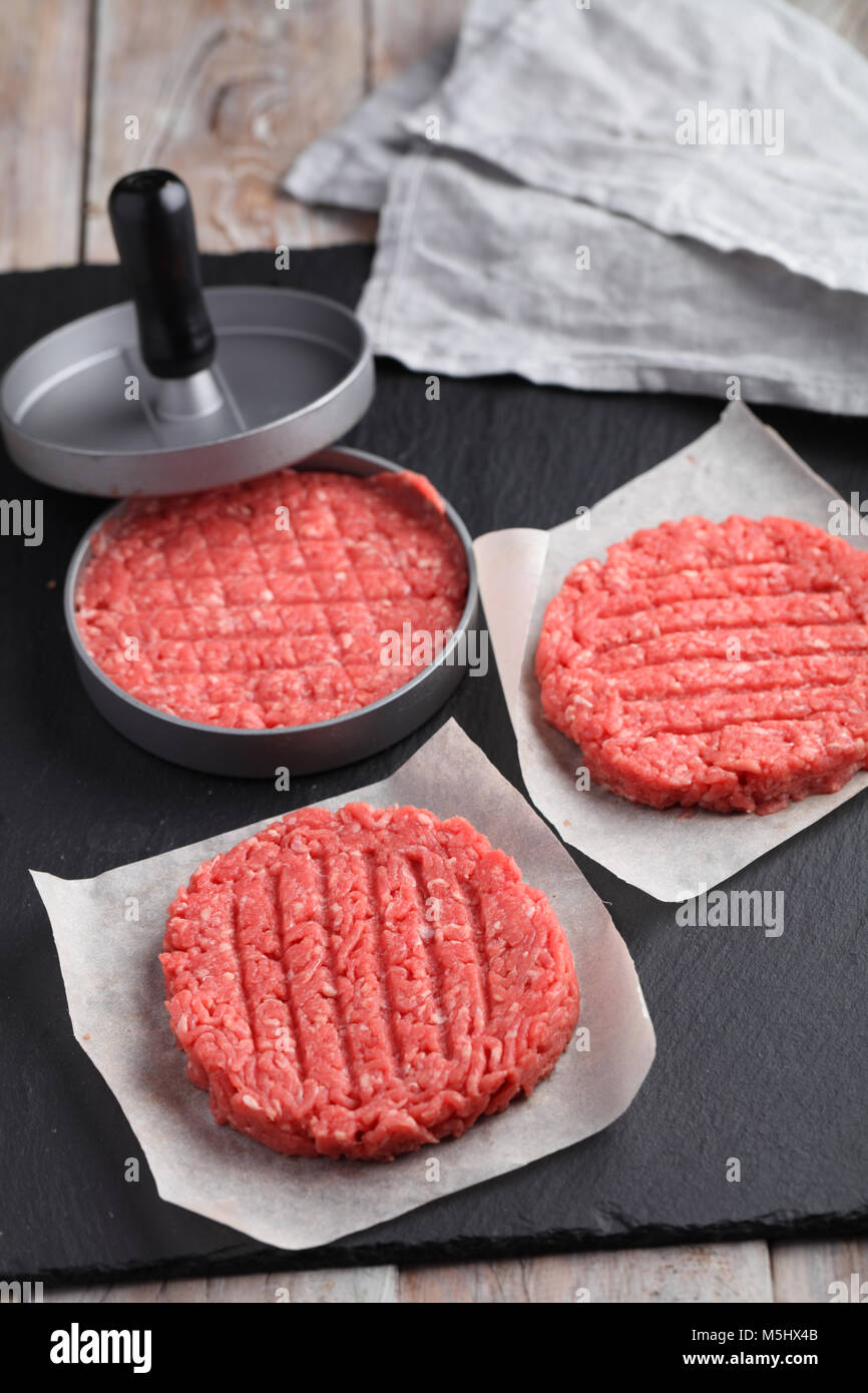 Cooking beef hamburgers from minced meat with meat press Stock Photo ...