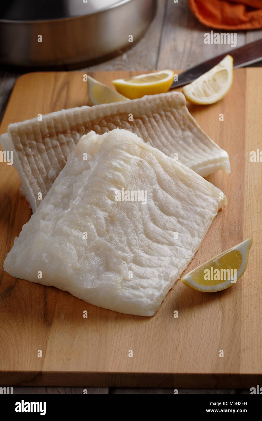 Raw codfish fillet on a rustic table Stock Photo - Alamy