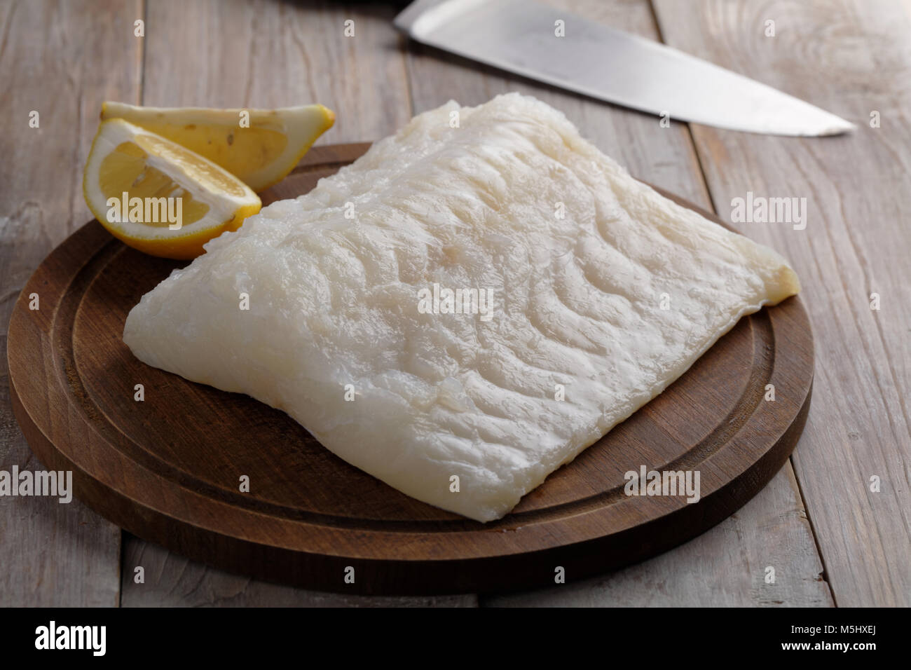 Raw codfish fillet on a rustic table Stock Photo - Alamy