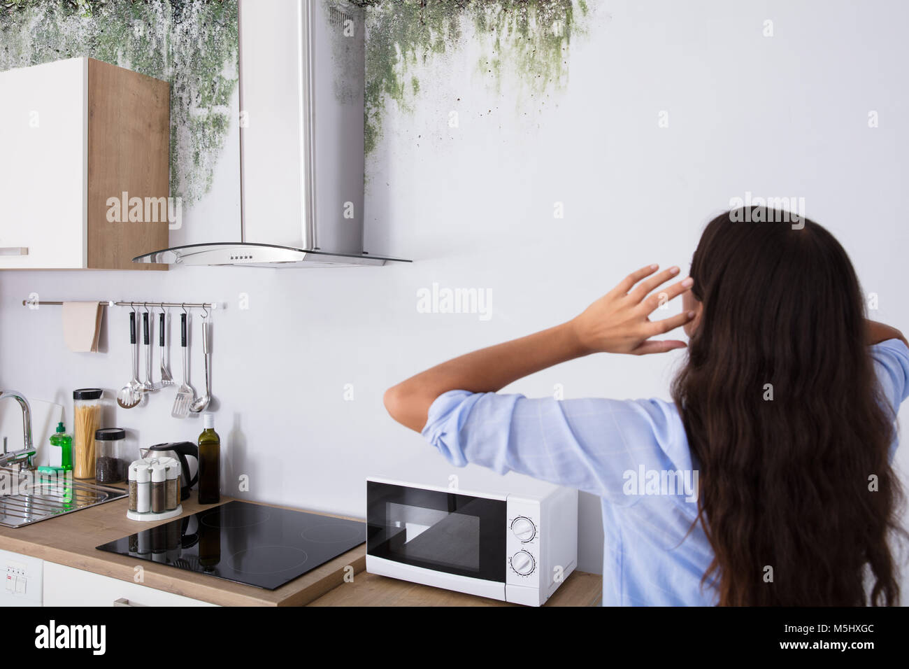 Rear View Of Shocked Woman Looking At The Damaged Ceiling In Kitchen ...