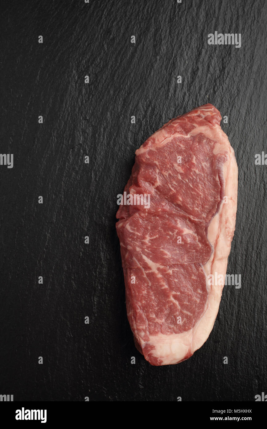 Raw steak of marbled Angus beef on a slate cutting board Stock Photo ...