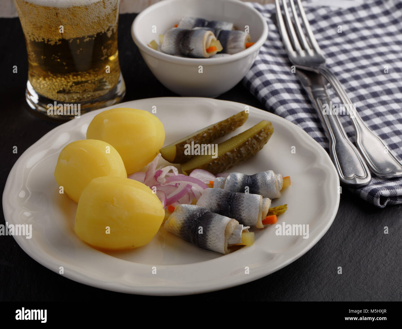 Rollmops with boiled potato, pickled cucumbers, red onion, and beer Stock Photo - Alamy
