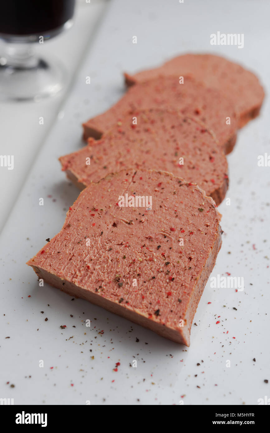 Slices of meat pate on the white plate. Selective focus on the front ...