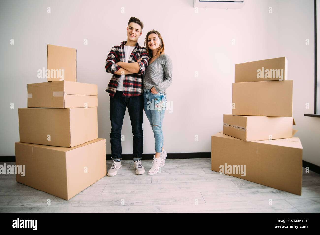 Young happy couple with boxes in apartment Stock Photo - Alamy