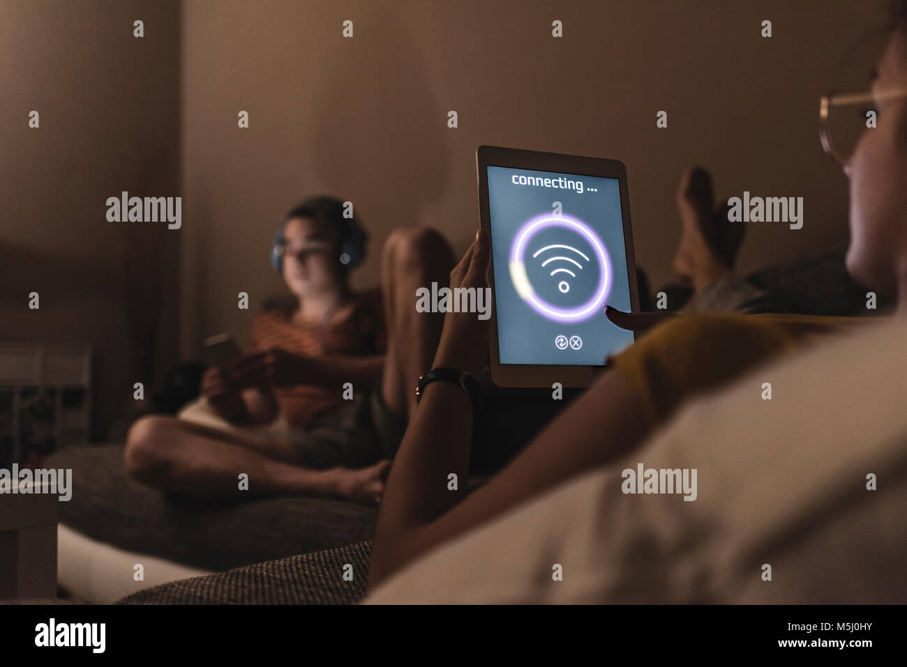 Couple relaxing on couch in smart home Stock Photo - Alamy