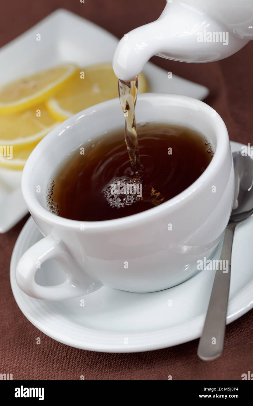 Pouring tea into a cup Stock Photo - Alamy