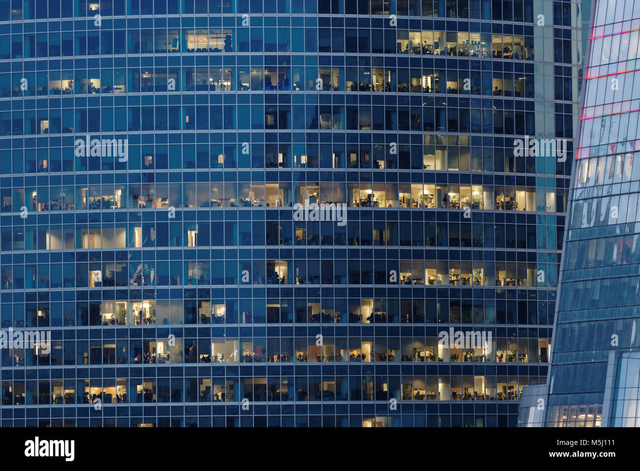 Background image of modern office building in the night Stock Photo - Alamy
