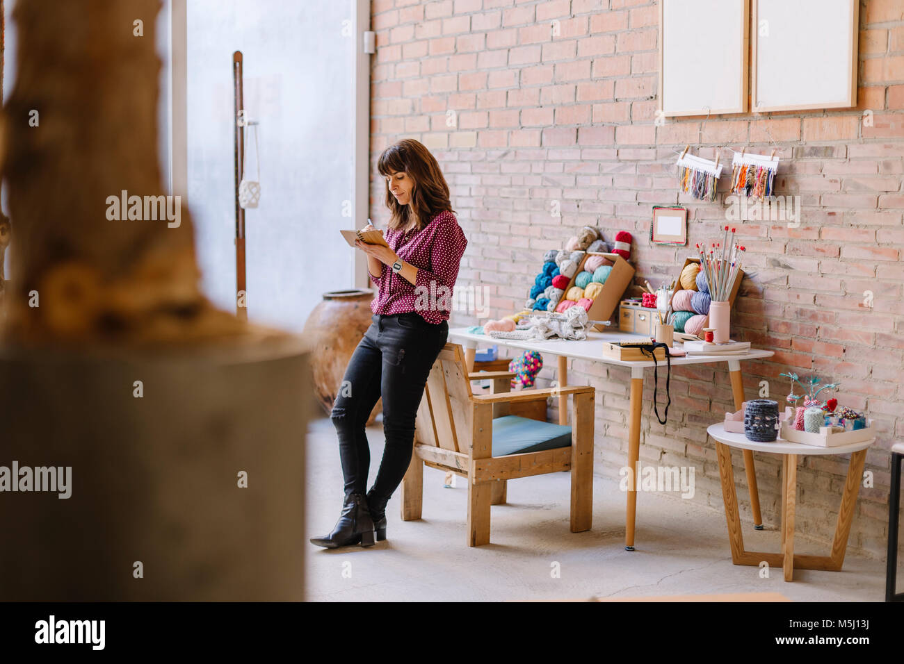 Woman in knitting studio taking notes Stock Photo - Alamy