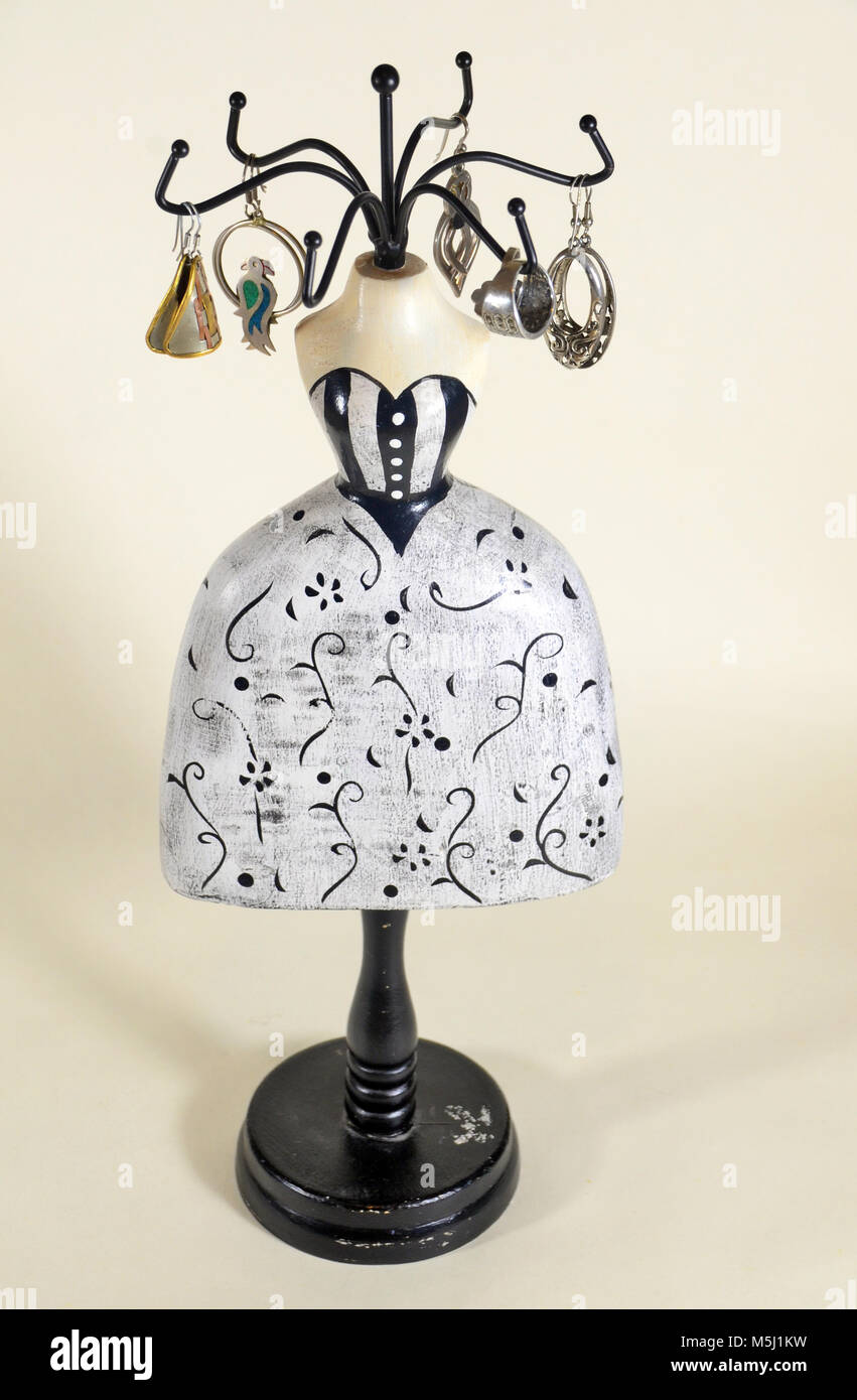 A painted lady mannequin jewellery stand with a display of earrings ...
