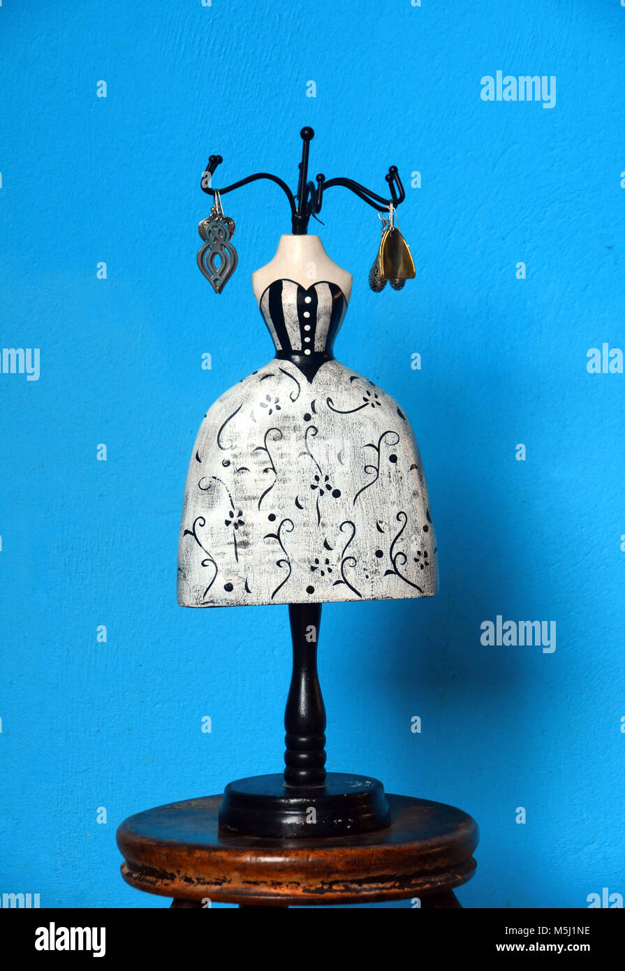 A painted lady mannequin jewellery stand with a display of earrings ...