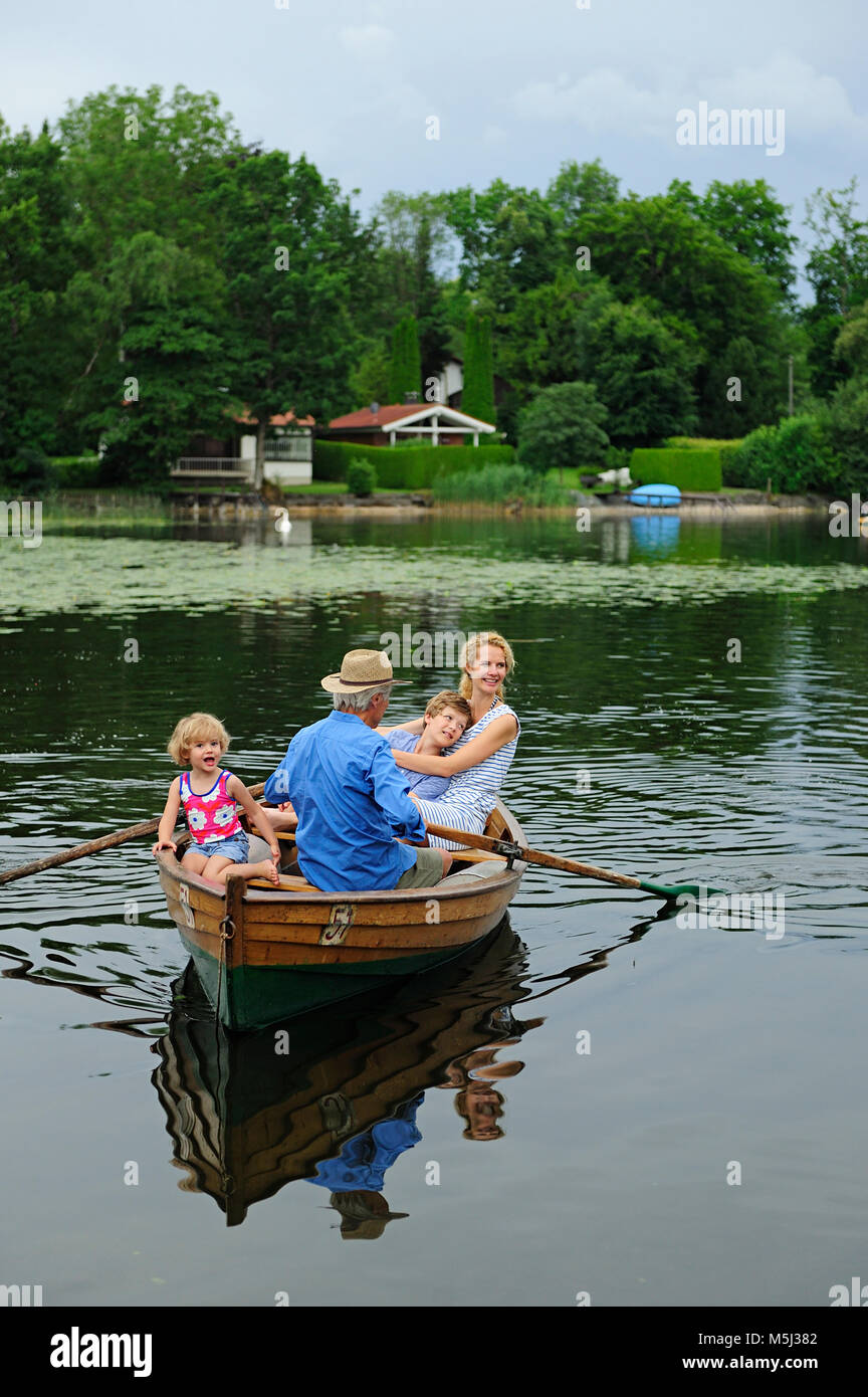 Happy family in rowing boat on lake Stock Photo - Alamy