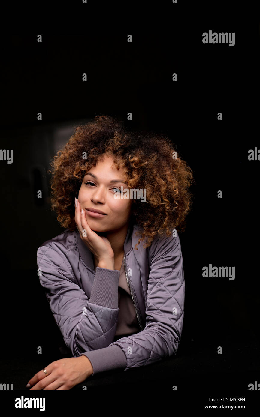 Portrait of woman against black background Stock Photo - Alamy