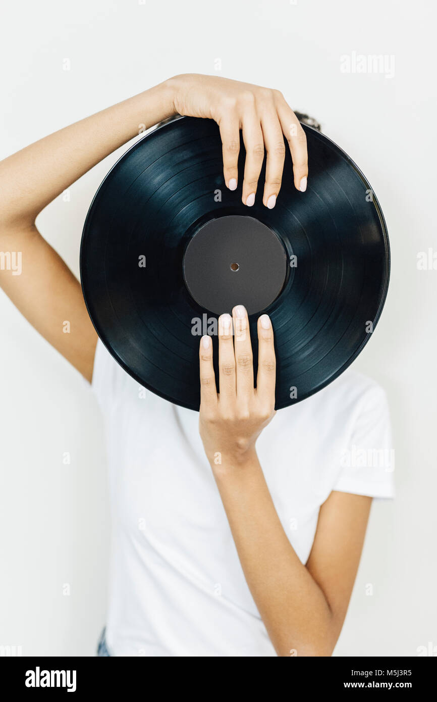 Young woman holding vinyl record in front of her face Stock Photo - Alamy