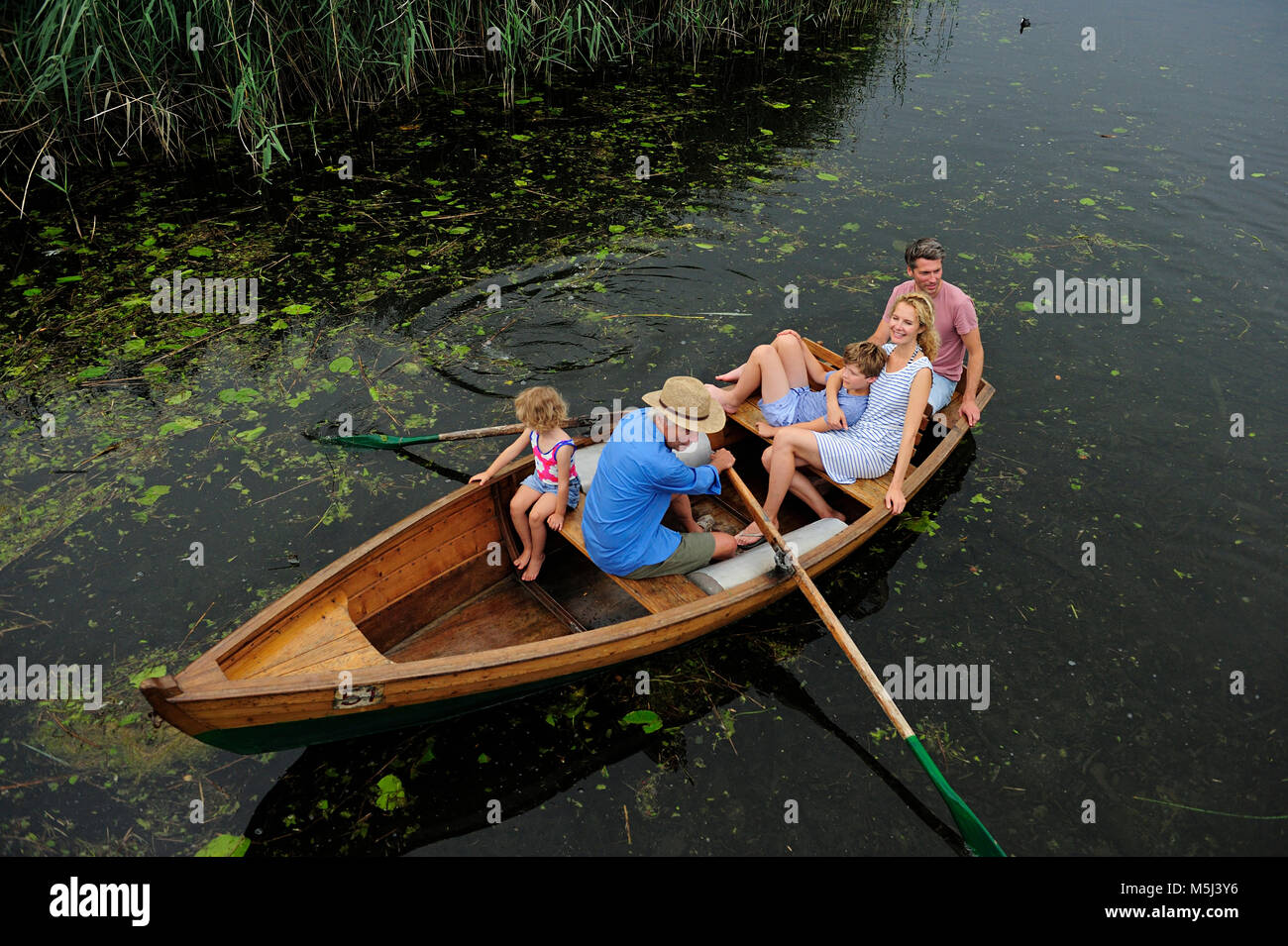 Family in rowing boat on lake Stock Photo - Alamy