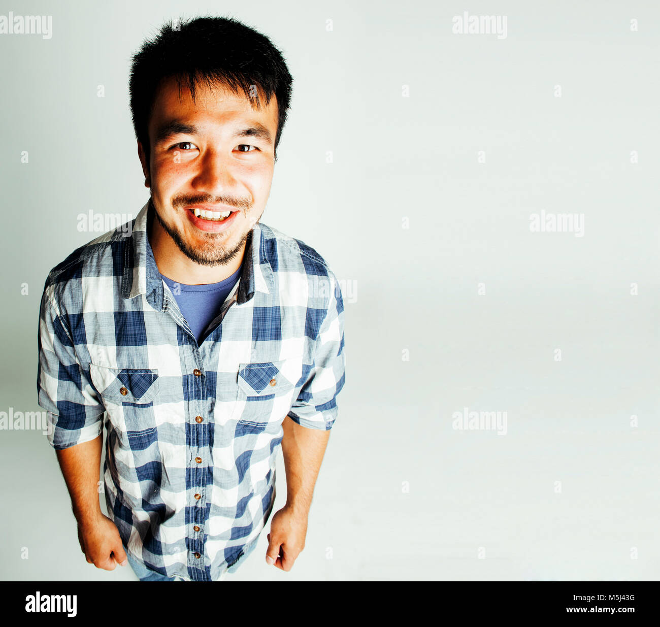 young cute asian man on white background gesturing emotional, pointing ...