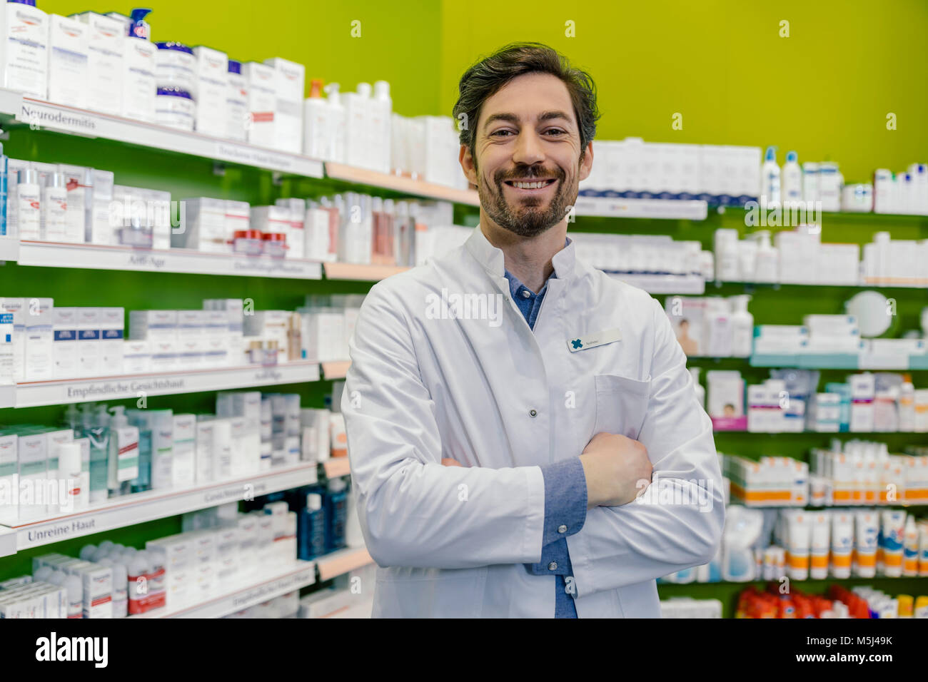 Portrait of smiling pharmacist at shelf with medicine in pharmacy Stock ...