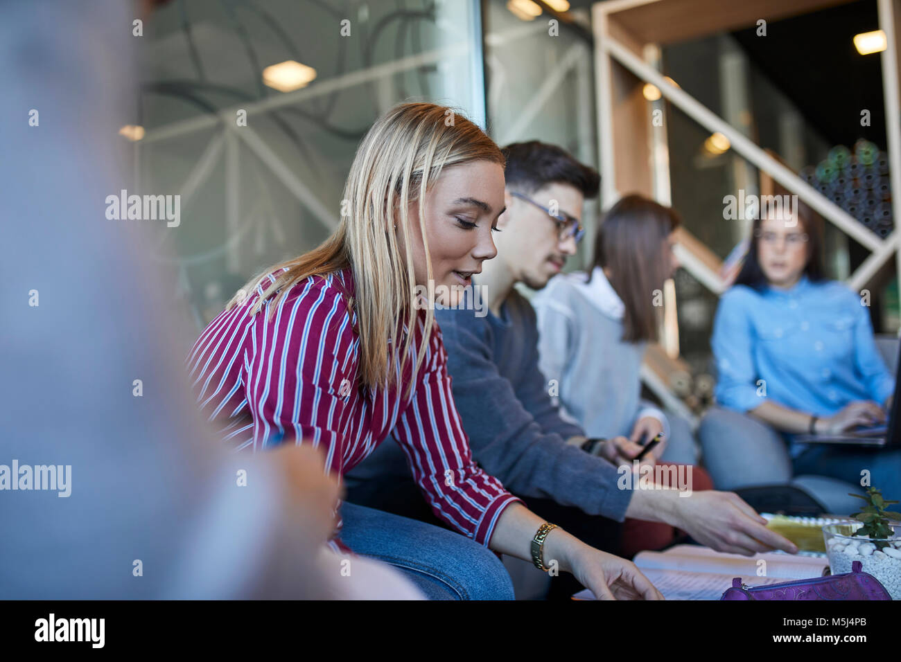 Group of friends sitting together in a cafe discussing documents Stock ...
