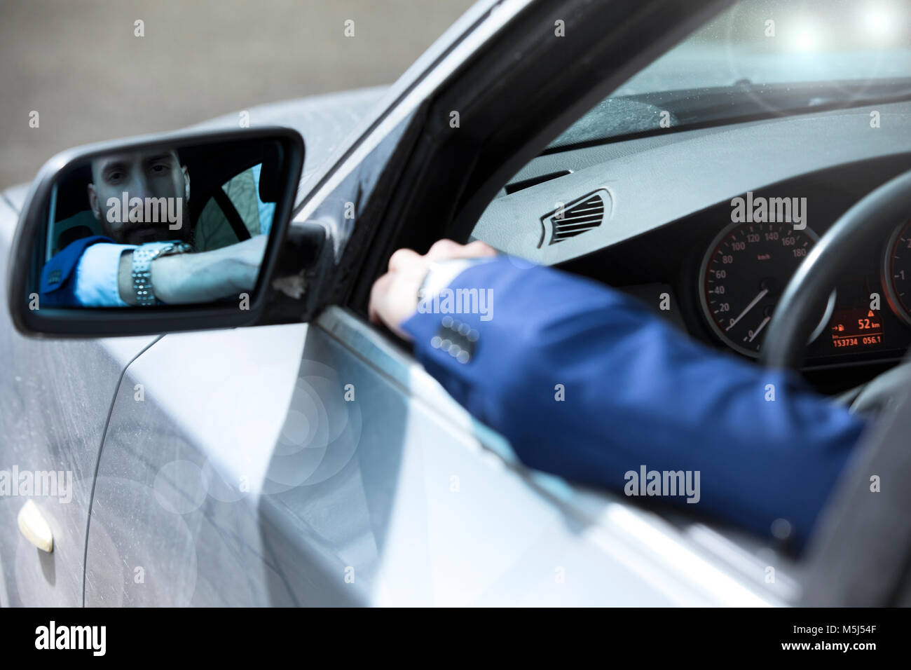 Young man driving his car, looking in wing mirror Stock Photo - Alamy
