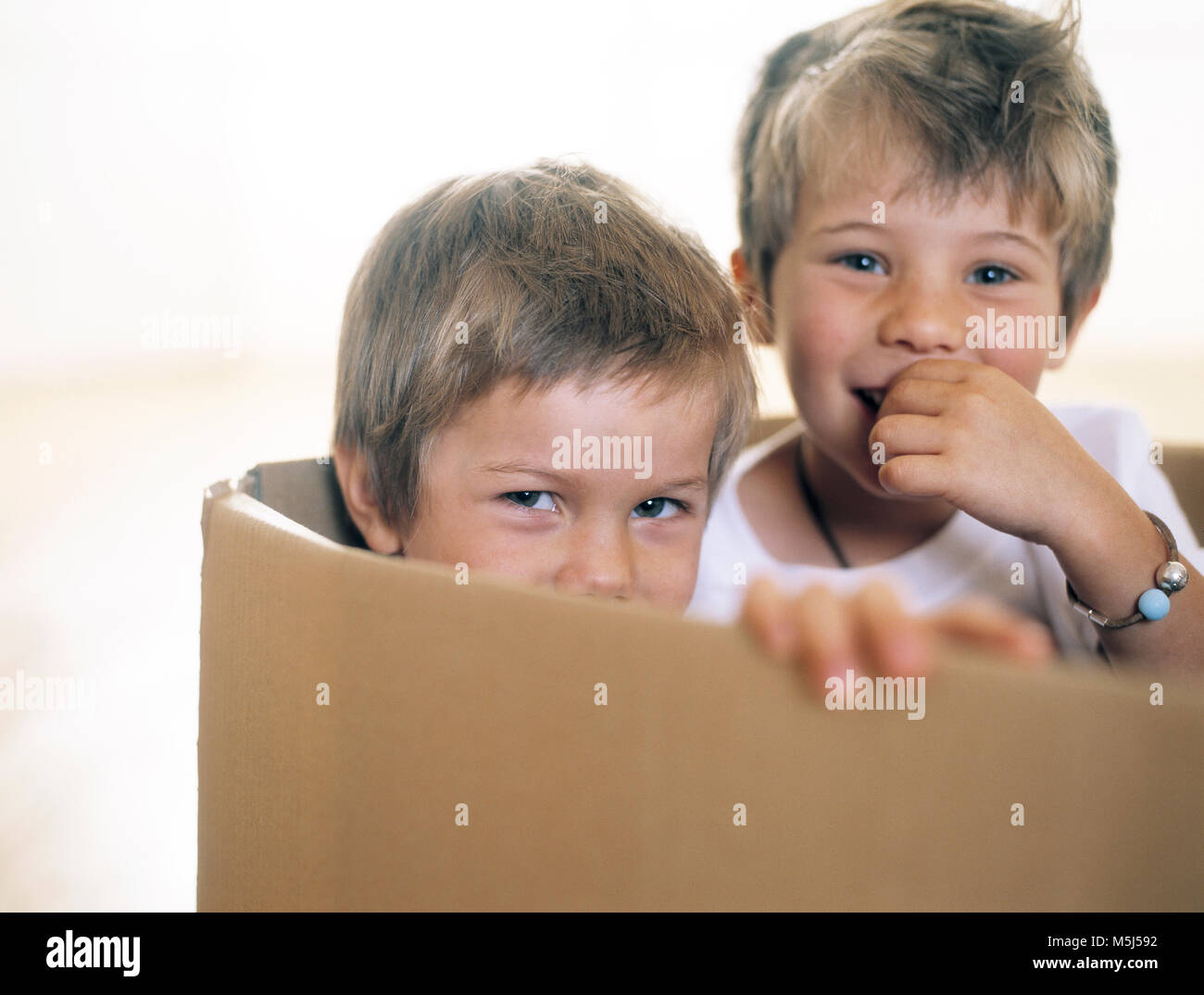 Two happy little children together in a cardboard box Stock Photo - Alamy
